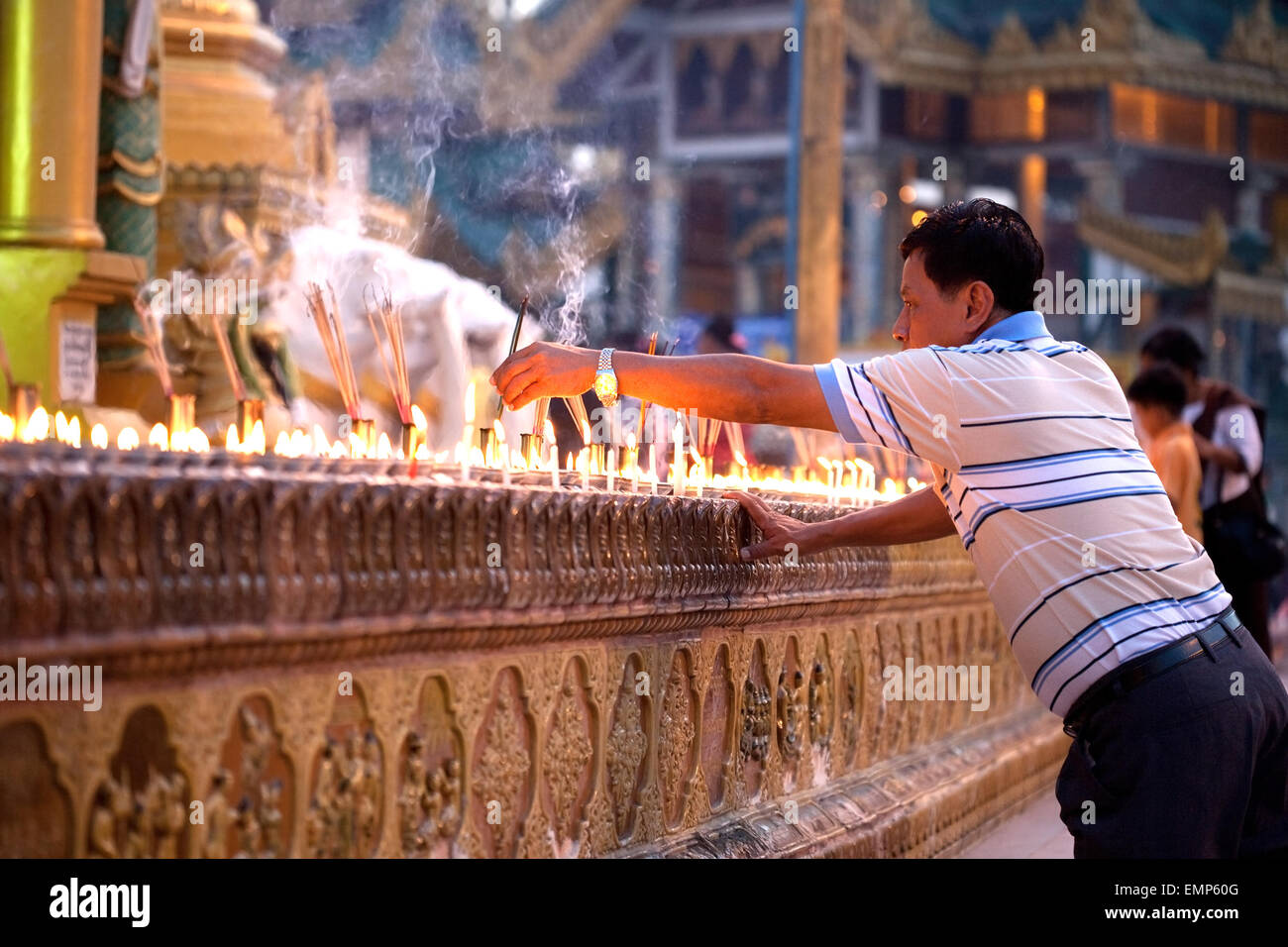 Buddhist devotees and monks lights up oil lamps in sacred temple of ...