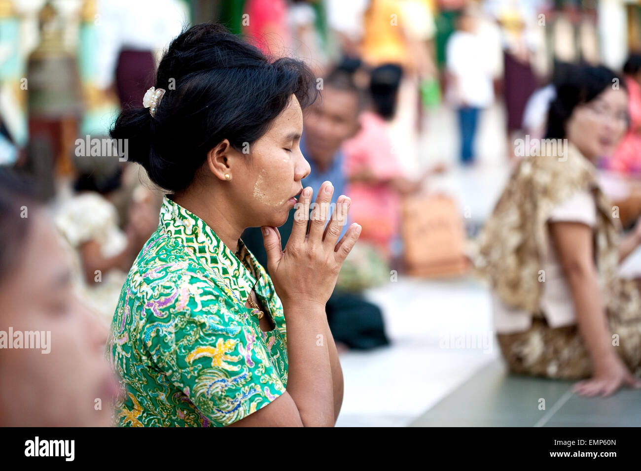 Buddhist devotees praying and giving offerings at Shwedagon temple ...