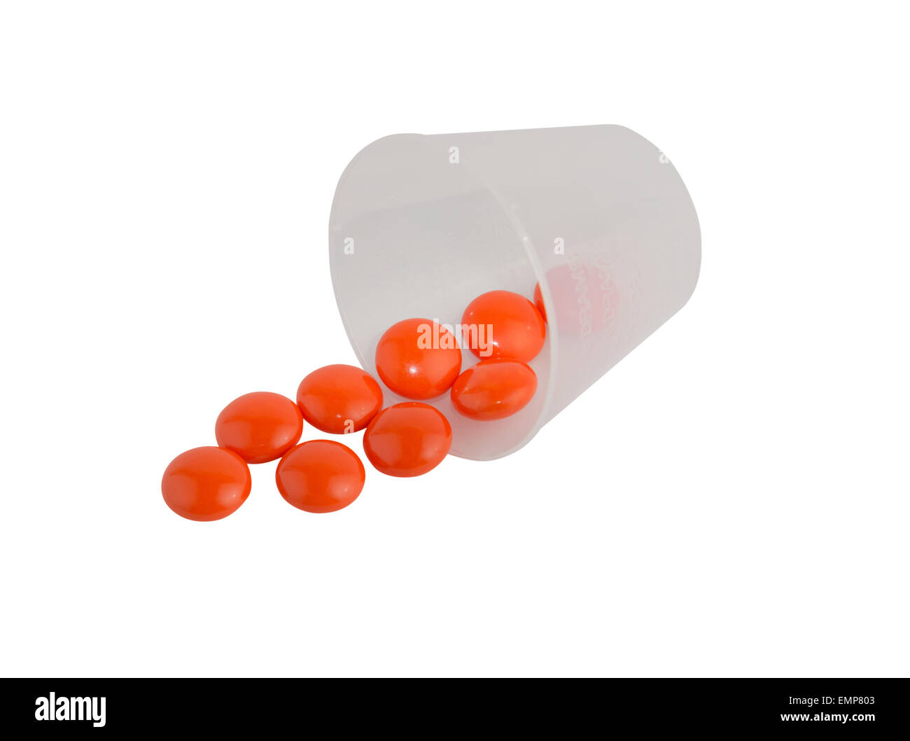 Red round tablets waking up from a plastic beaker Stock Photo - Alamy