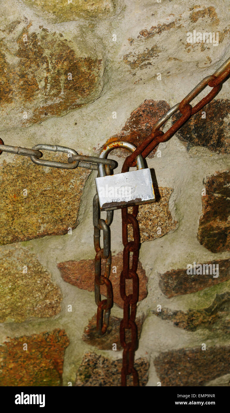 the old powerful lock connects the ends of a rusty chain hanging on a ...