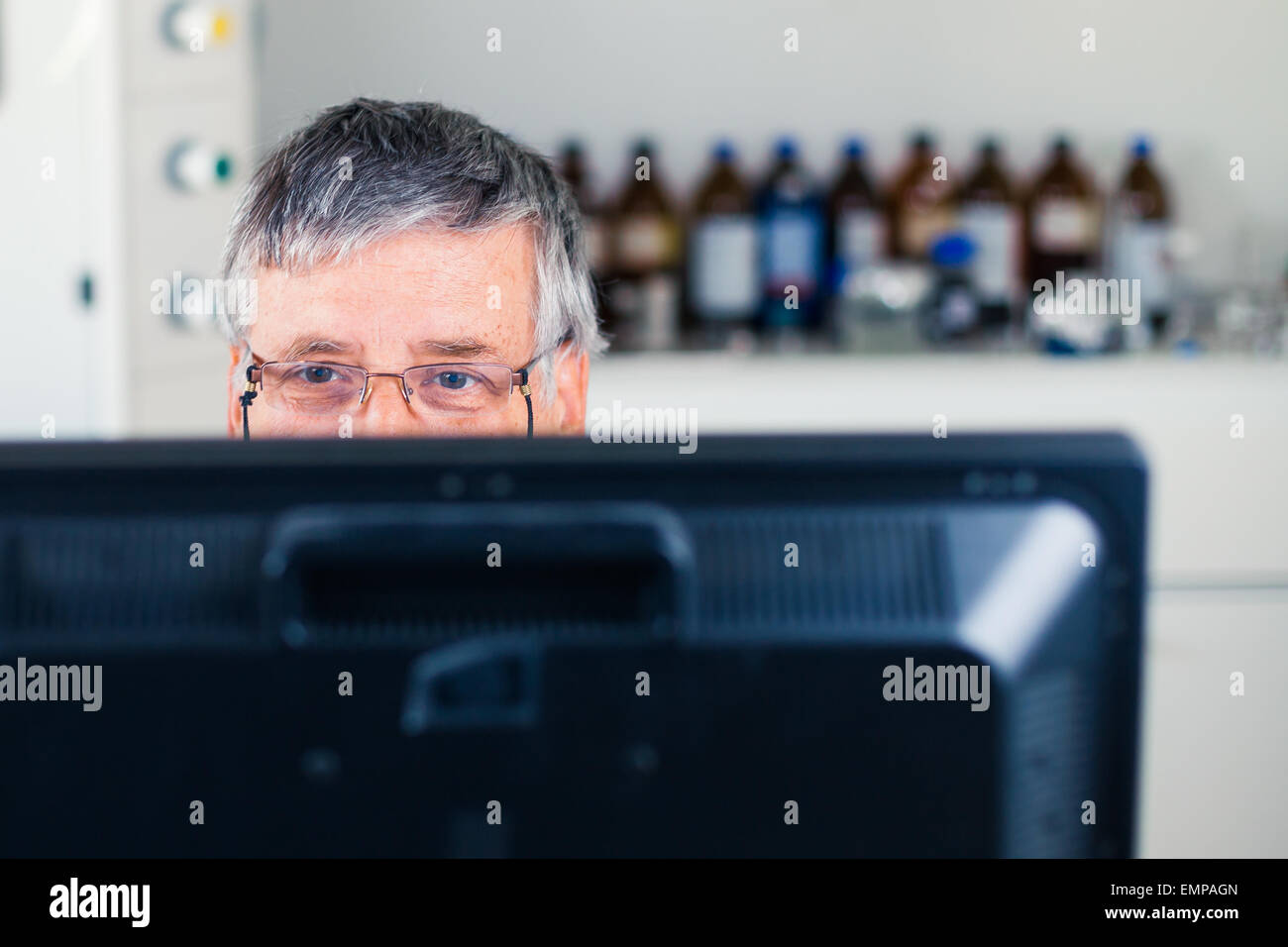 Senior researcher using a computer in the lab while working on an ...