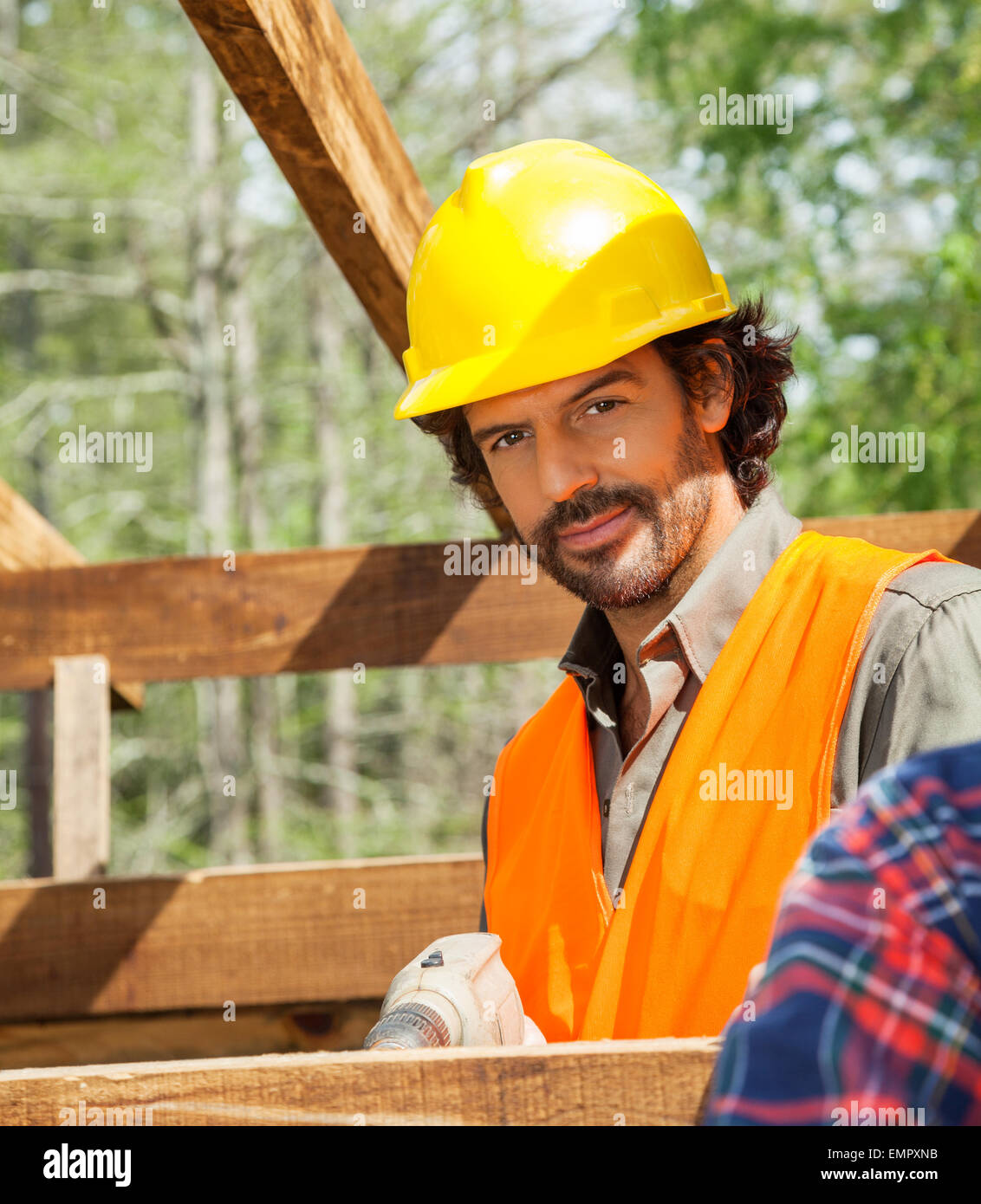 Confident Worker Drilling On Timber Frame At Site Stock Photo - Alamy