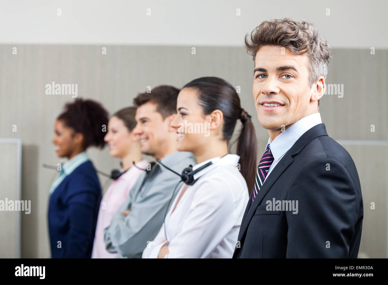 Smiling Manager Standing In Row With Team Stock Photo - Alamy