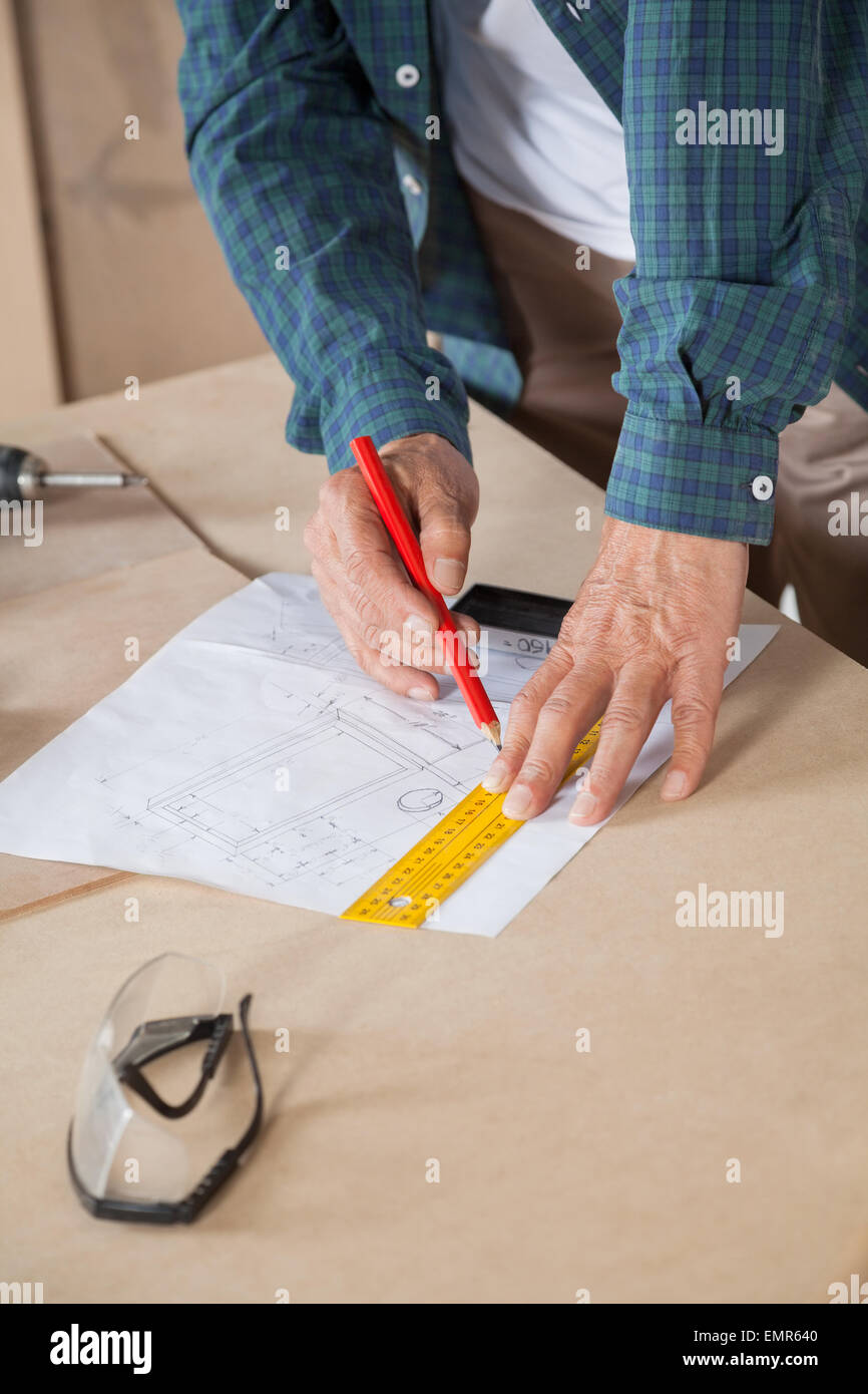 Midsection Of Carpenter Drawing Blueprint At Table Stock Photo - Alamy