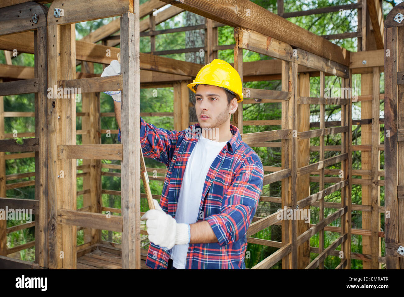 Worker Taking Measurements In Wooden Cabin Stock Photo - Alamy