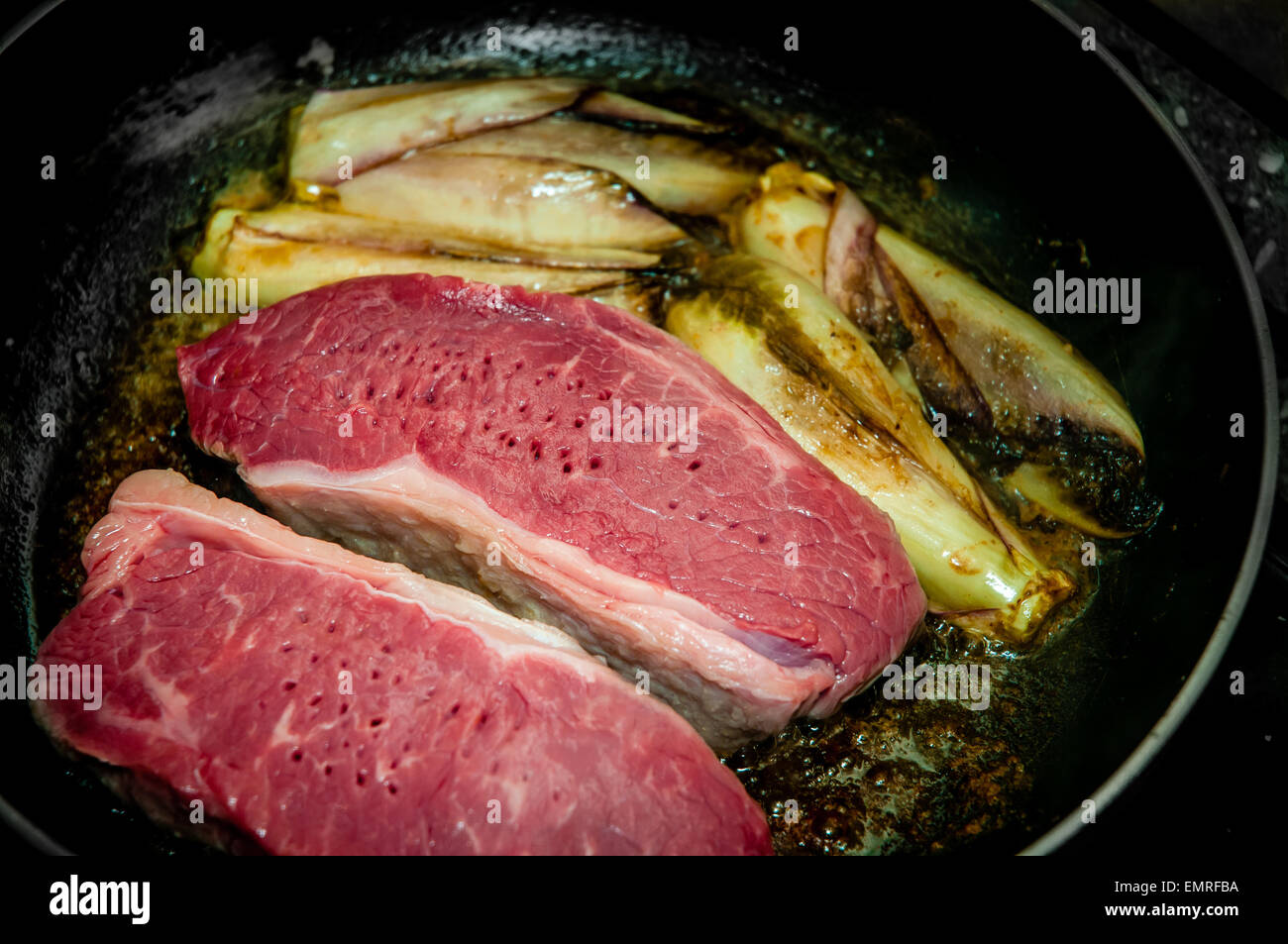 Raw beef tenderloins with endives in a pan Stock Photo - Alamy