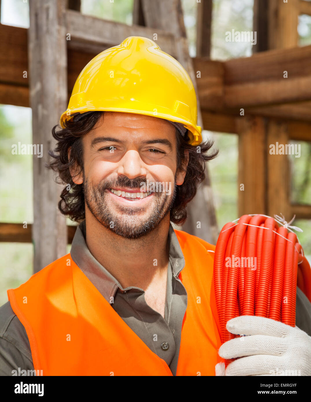Confident Male Worker With Pipe At Construction Site Stock Photo - Alamy