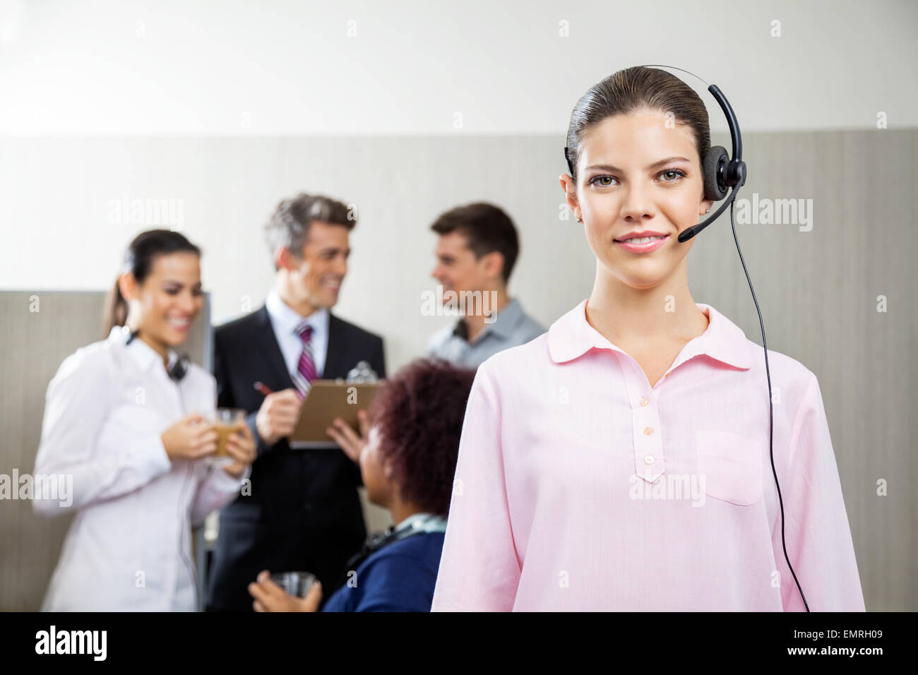 Confident Female Customer Service Representative Standing At Off Stock ...