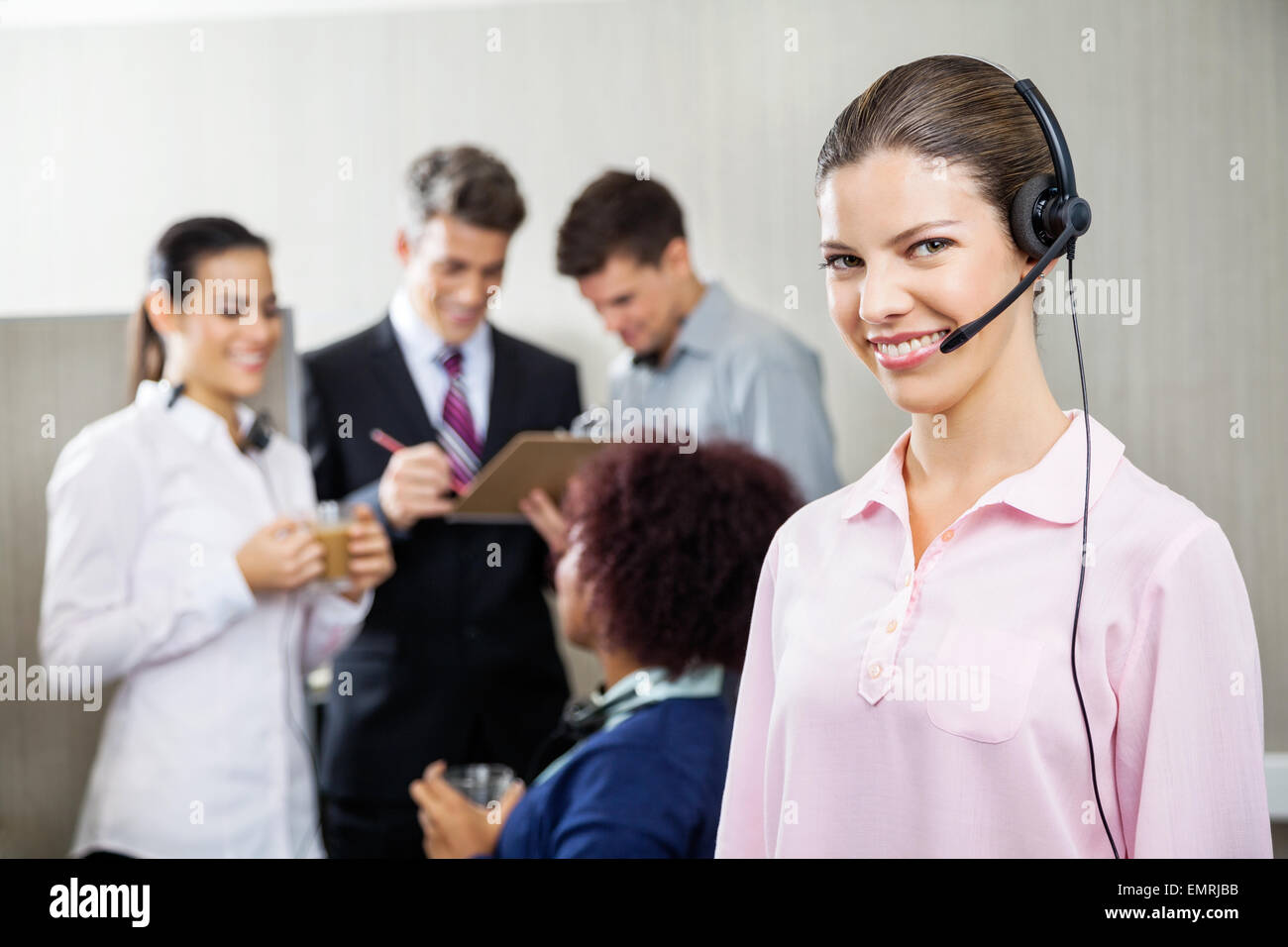 Happy Female Service Agent Standing At Call Center Stock Photo - Alamy