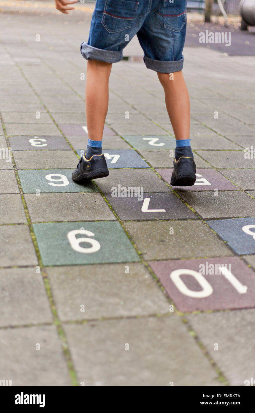 Boy playing hopscotch outside on the pavement Stock Photo - Alamy