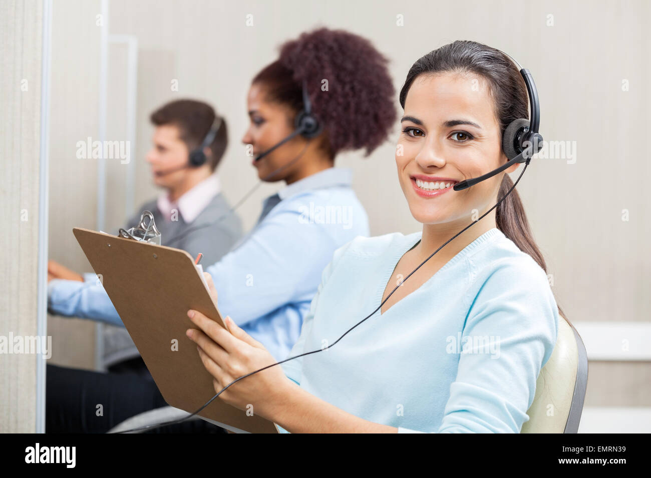 Smiling Female Customer Service Representative Writing On Clipbo Stock ...