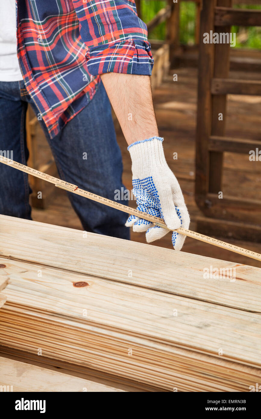 Construction Worker Measuring Timber With Tape Stock Photo - Alamy