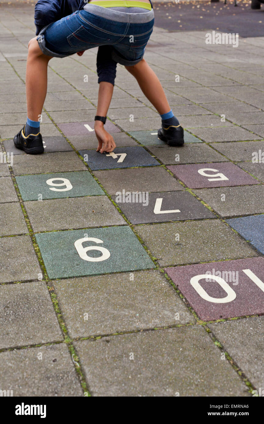 Boy playing hopscotch outside on the pavement Stock Photo - Alamy