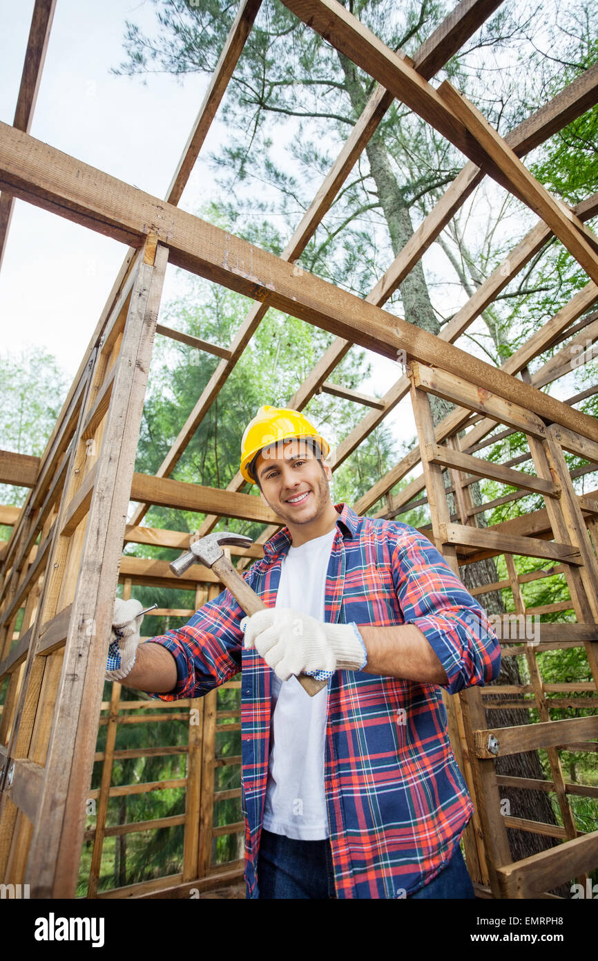 Smiling Construction Worker Hammering In Timber Cabin Stock Photo - Alamy