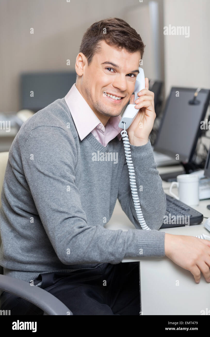 Male Customer Service Representative Using Telephone At Desk Stock ...