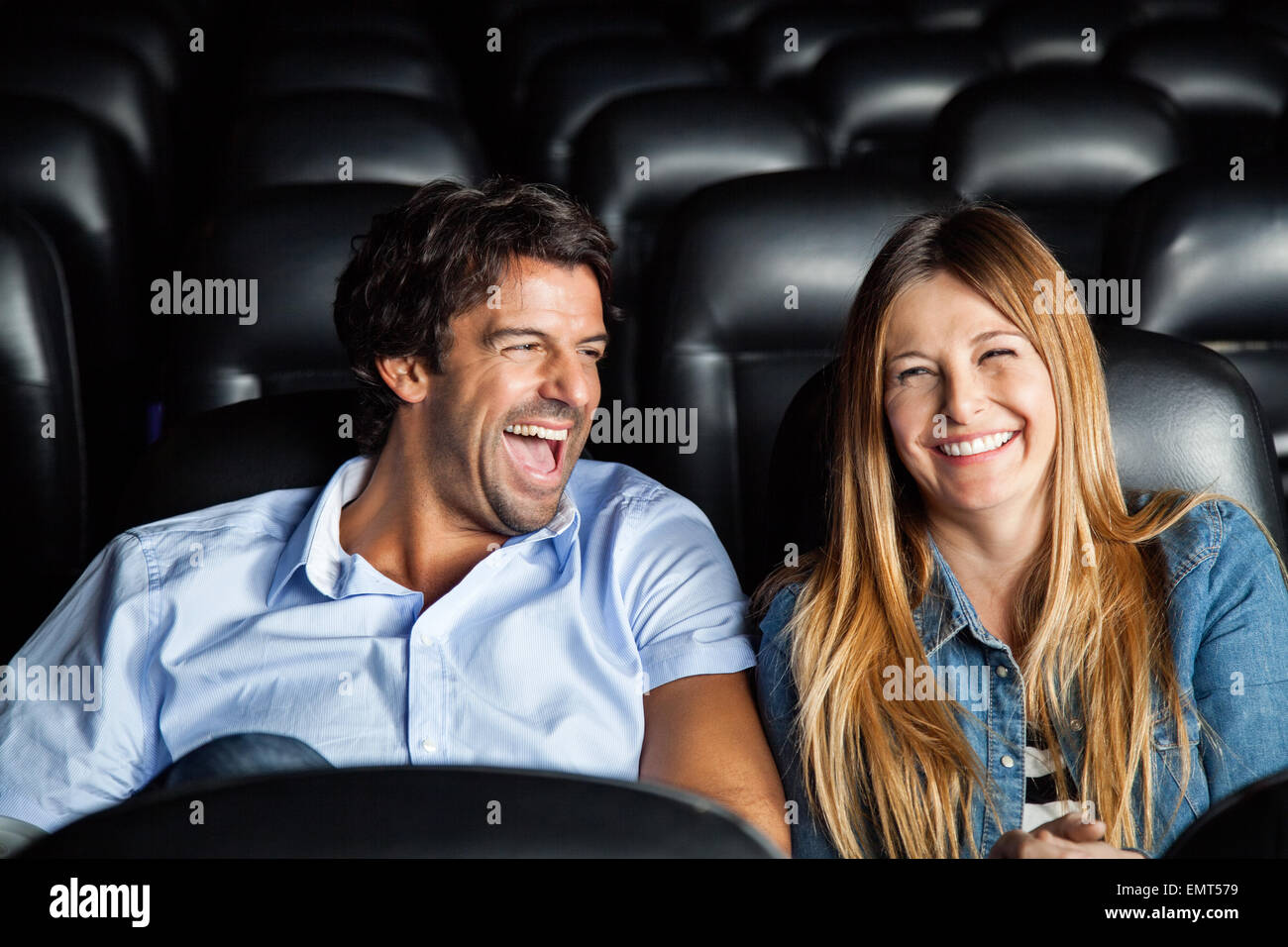 Couple Laughing While Watching Film In Theater Stock Photo - Alamy