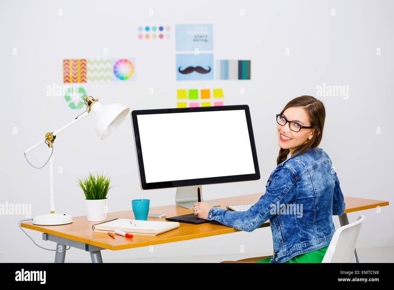 Woman working at desk In a creative office, using a computer Stock ...