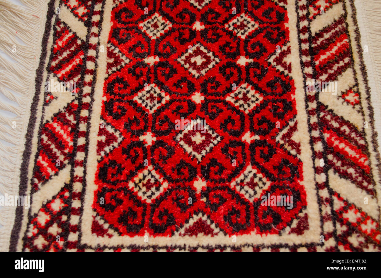 Small wool rug with red background Stock Photo - Alamy