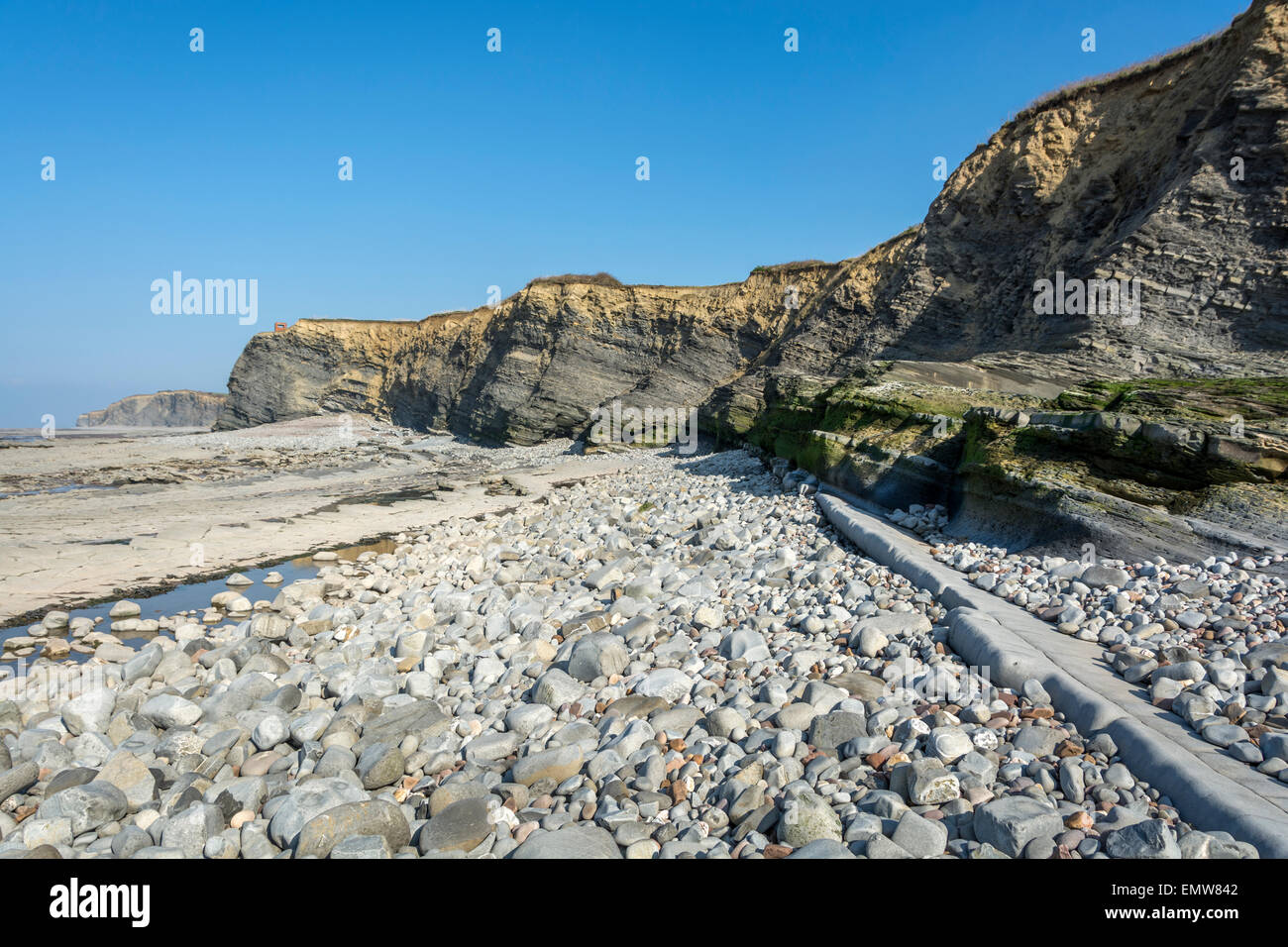 Layers of sedimentary rocks make interesting patterns on the beach and ...