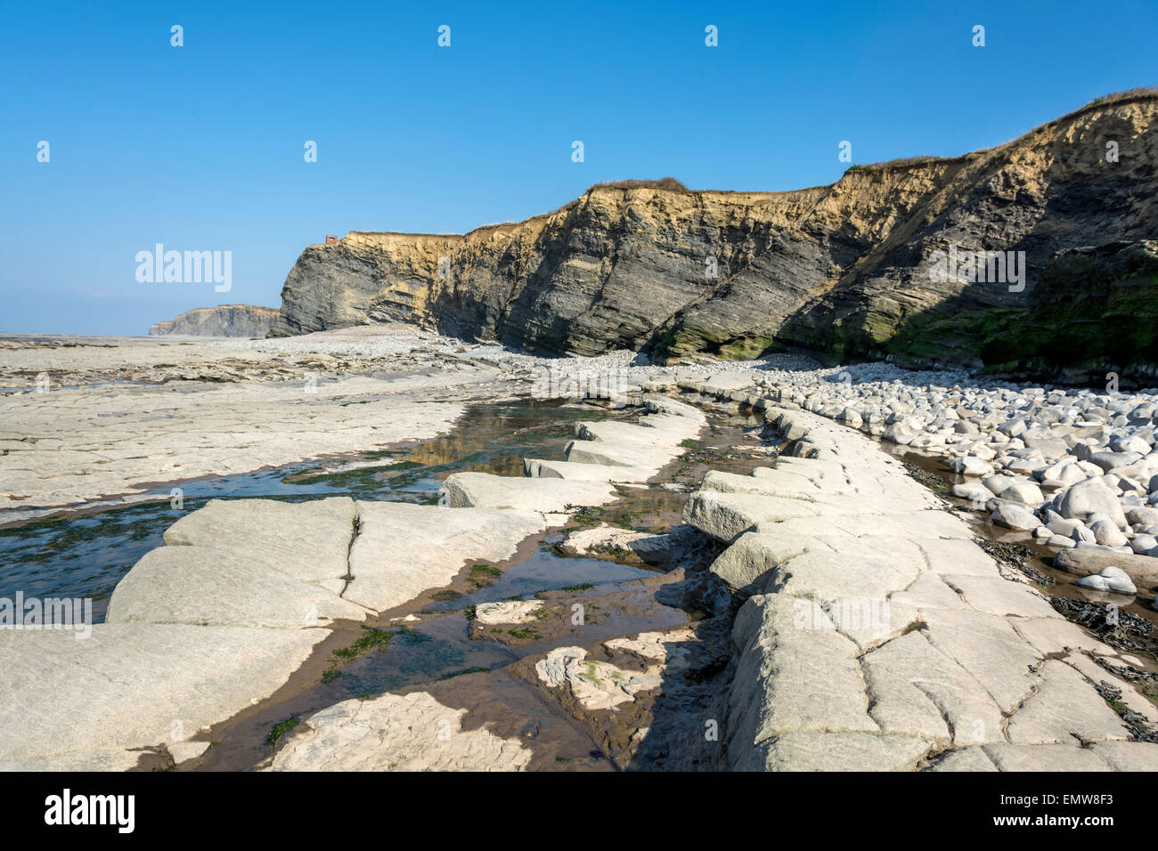 Layers of sedimentary rocks make interesting patterns on the beach and ...