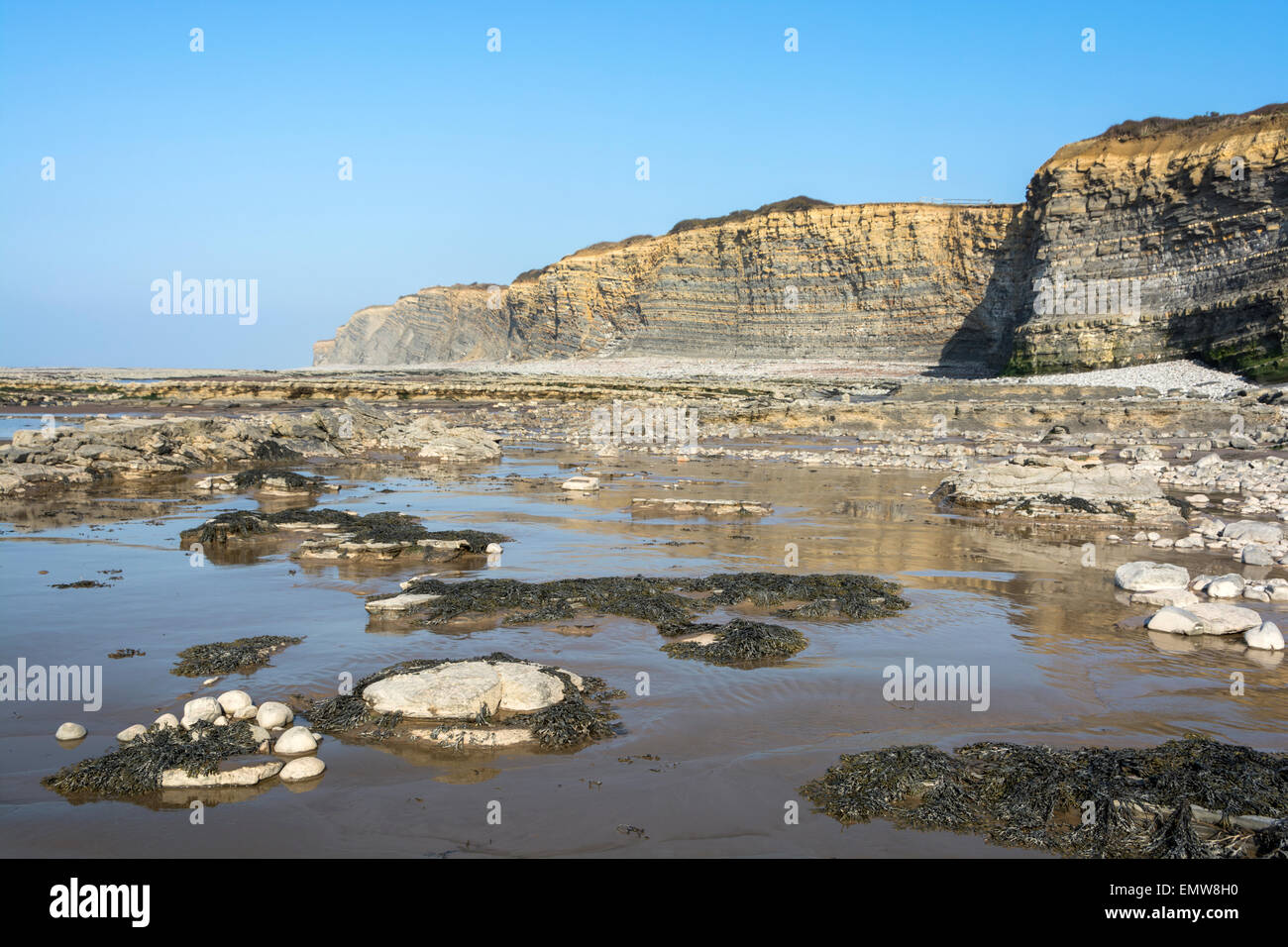 Layers of sedimentary rocks make interesting patterns on the beach and ...