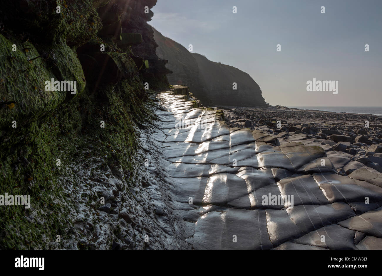 Layers of sedimentary rocks make interesting patterns on the beach and ...