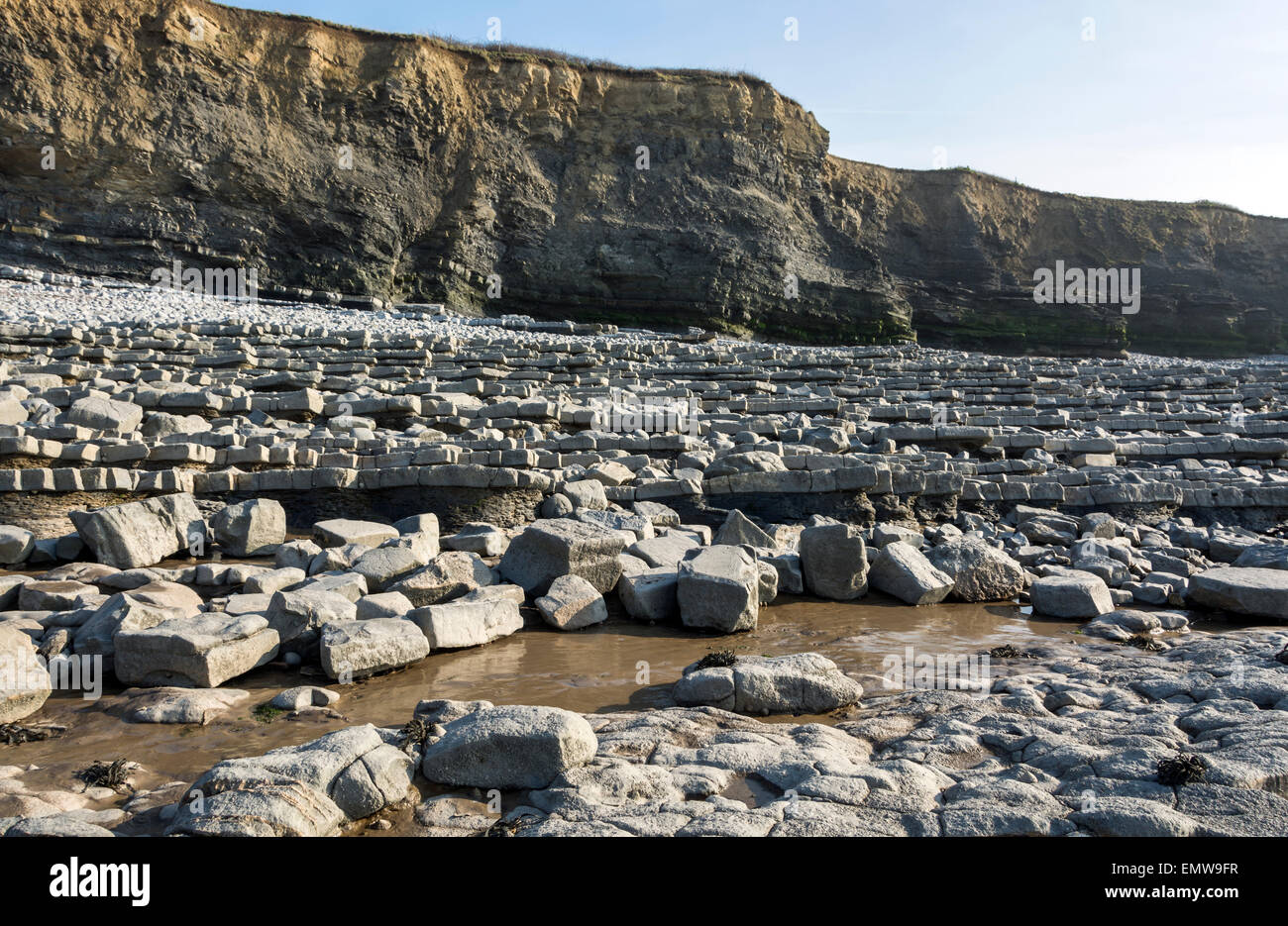 Layers of sedimentary rocks make interesting patterns on the beach and ...