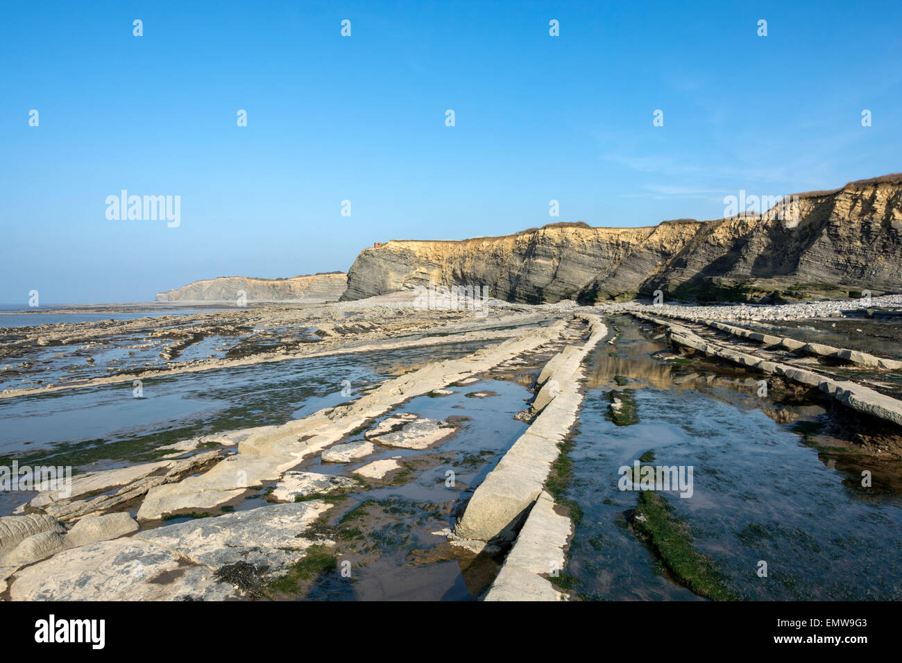 Layers of sedimentary rocks make interesting patterns on the beach and ...