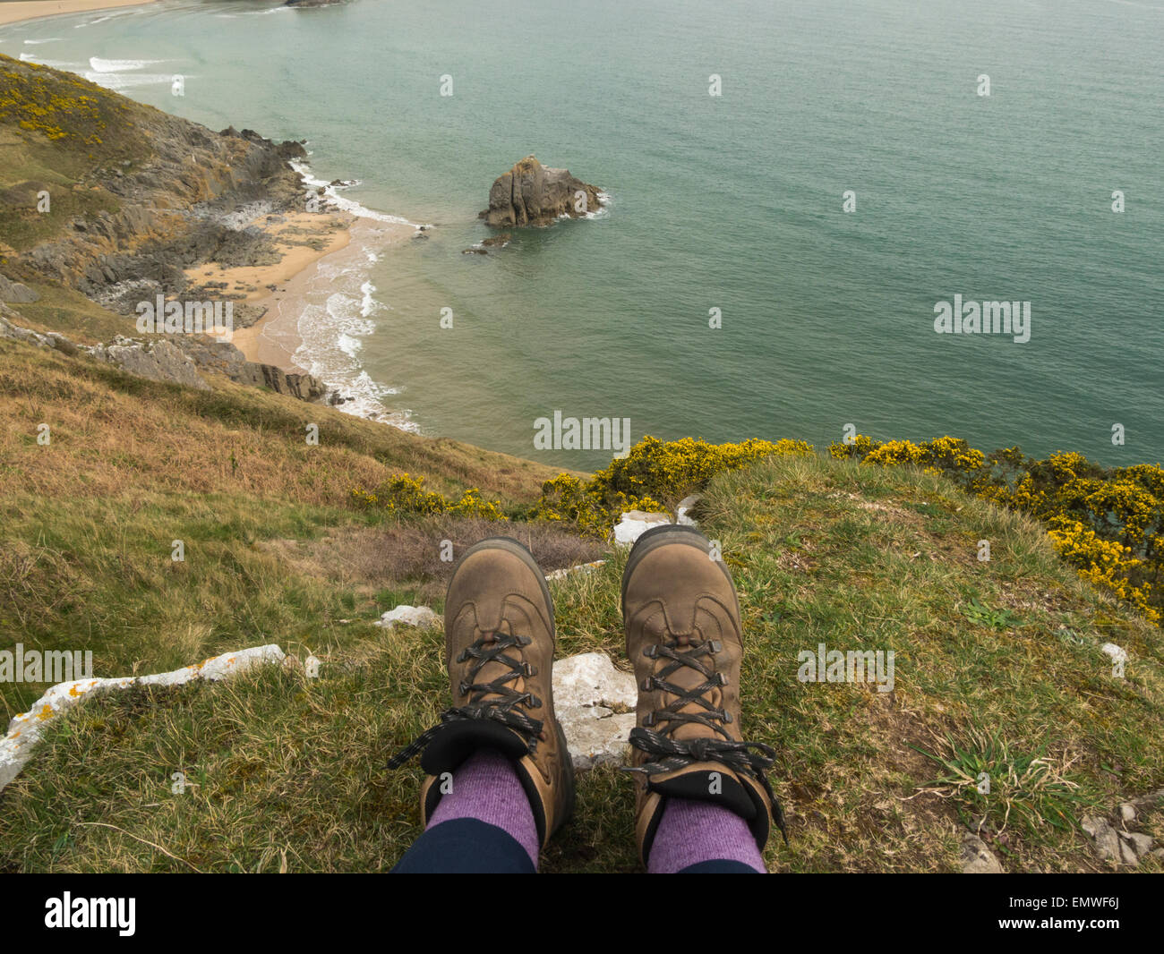 Pair walking boots over view down to Threecliff Bay Gower Peninsula ...