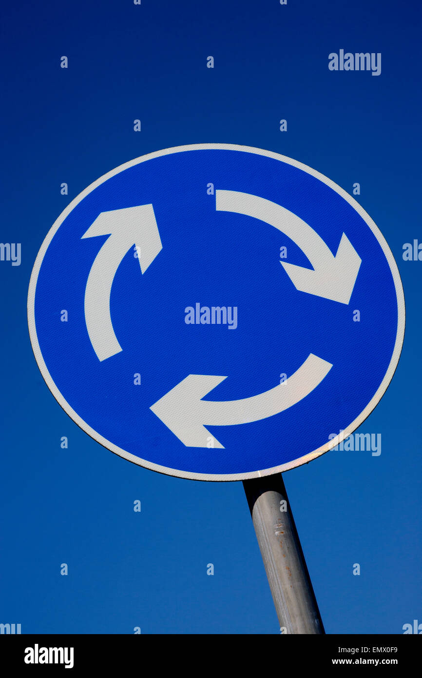 Blue UK roundabout sign against bright blue sky. England Stock Photo ...
