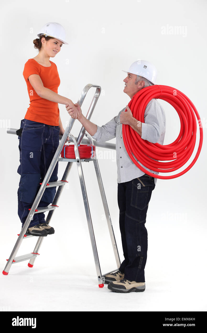 Two plumbers being polite Stock Photo - Alamy