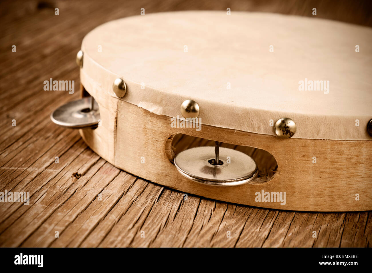 closeup of a tambourine on a rustic wooden table, heavy processing for ...