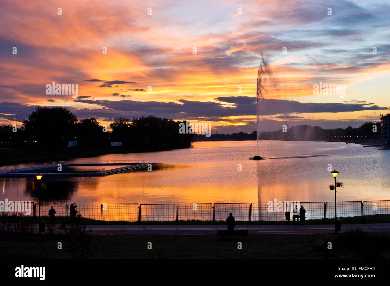 Sunset watchers by the lake on the Ada river island Stock Photo - Alamy