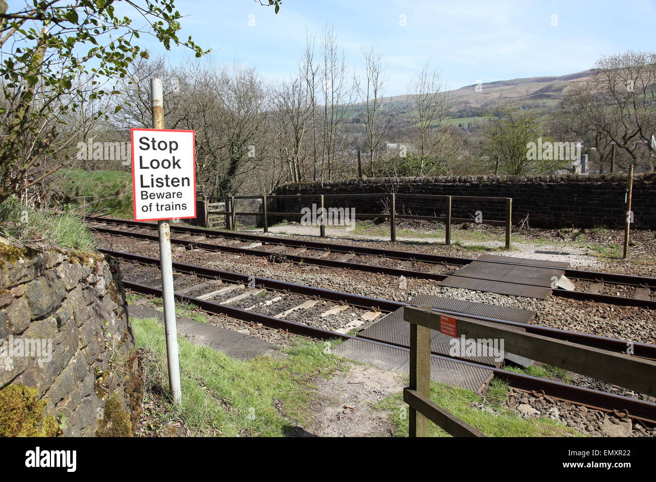 A train passes through a pedestrian level crossing near Uppermill ...