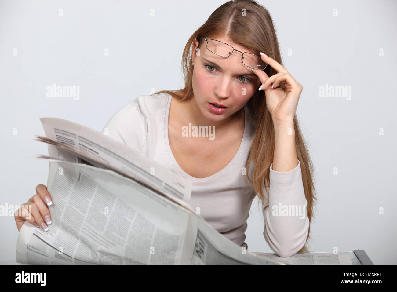 Woman shocked by newspaper article Stock Photo - Alamy