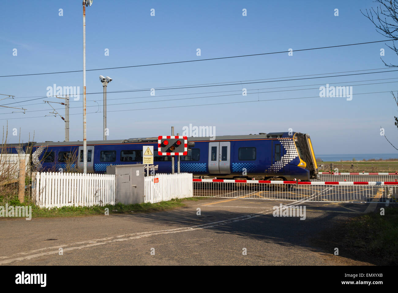 Scotrail train passing through a level crossing Stock Photo - Alamy