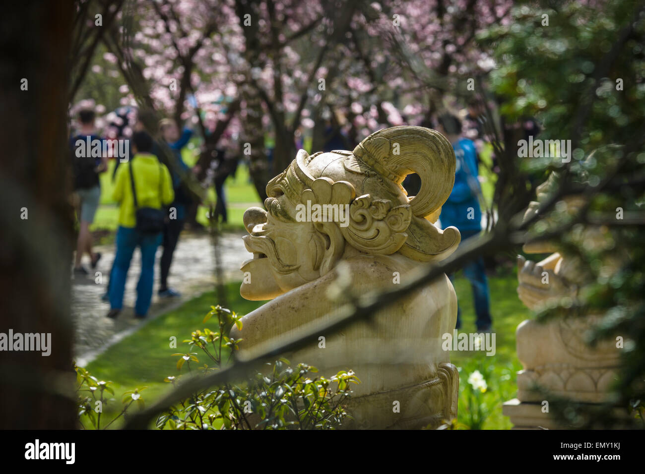 Korean stone idol in the flowered spring park. A view through the trees ...