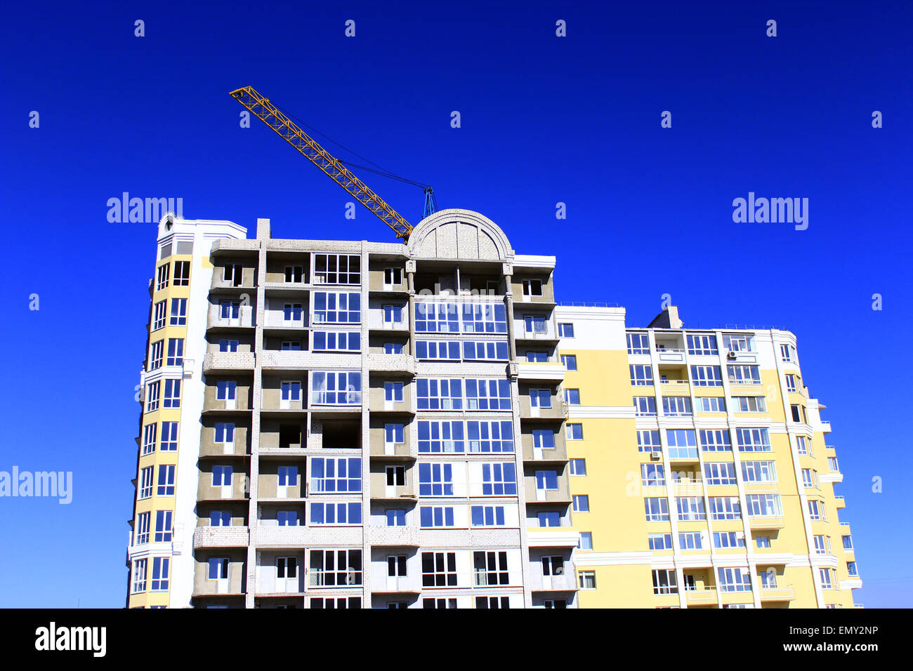construction of multistory modern house with hoisting crane on the blue ...