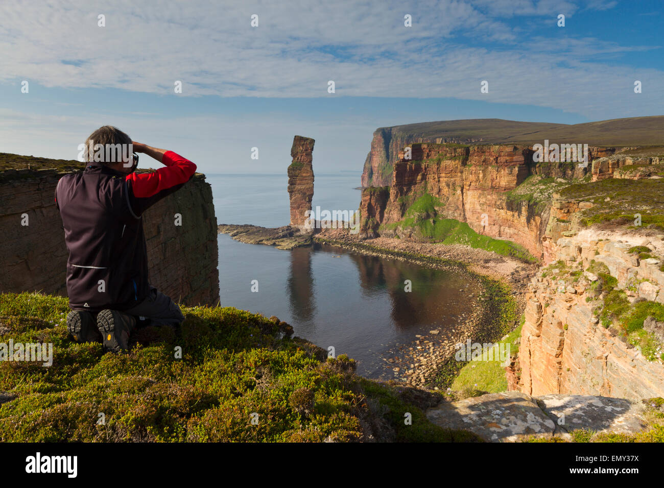 Male photographing cliffs of Hoy including sea stack, Orkney Islands ...