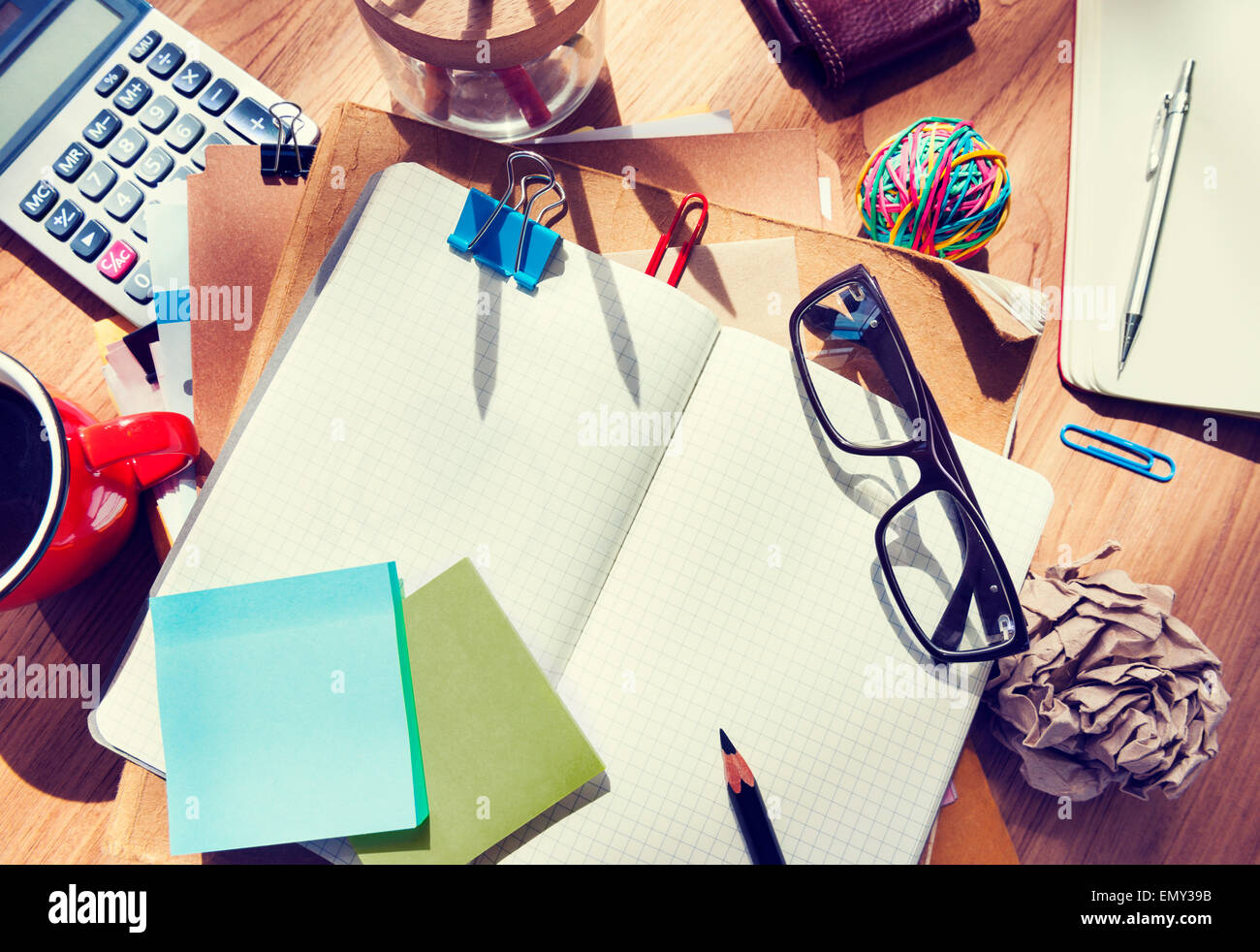 Messy Designer's Table with Blank Note and Tools Stock Photo - Alamy
