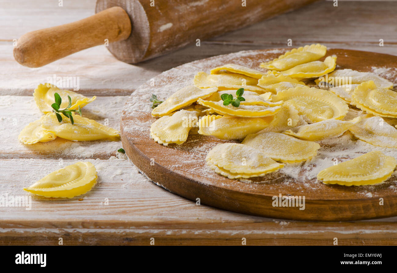 Fresh Ravioli on with flour on a wooden backround. Selective focus ...