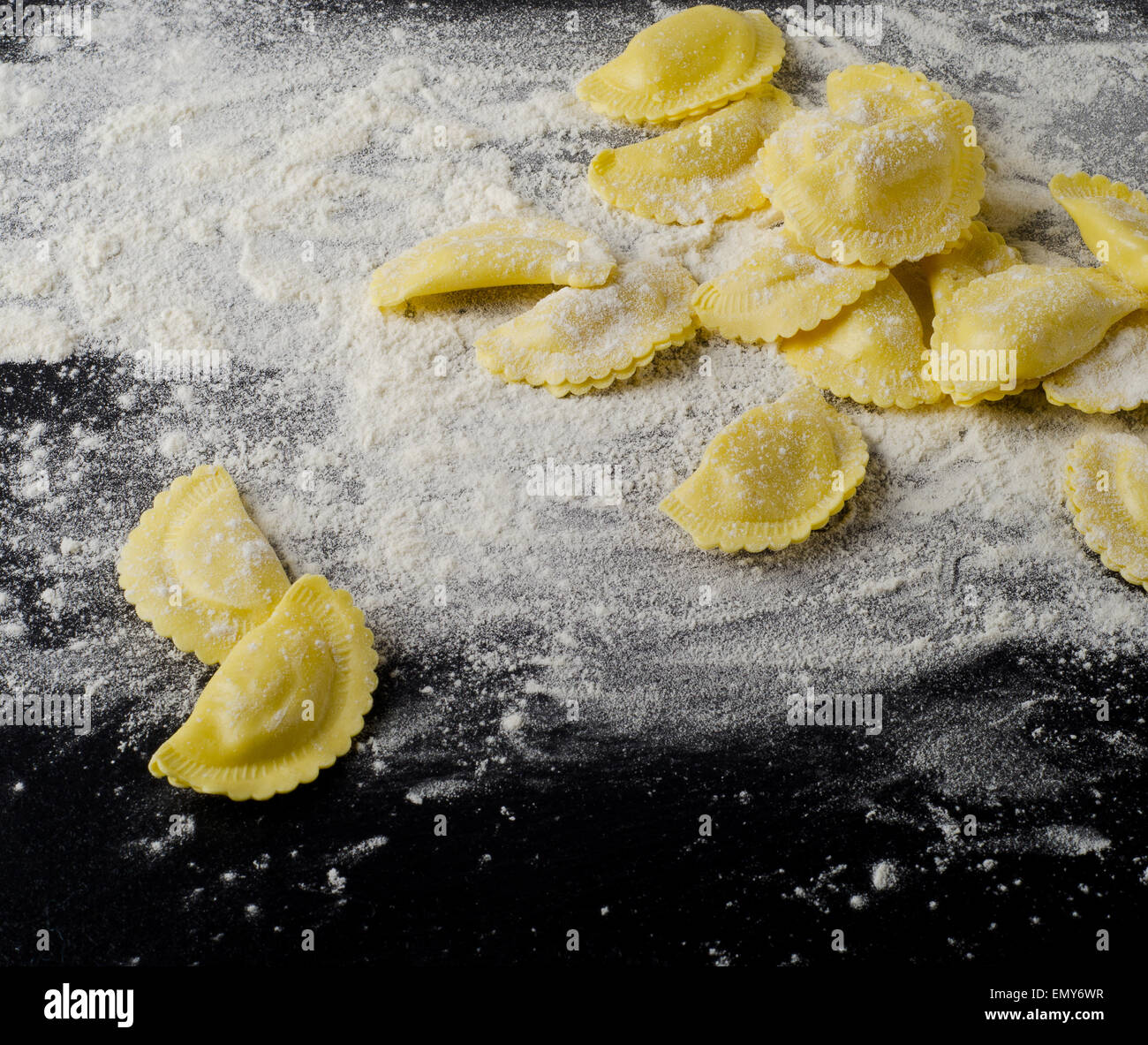 Italian raw ravioli on black table. Selective focus Stock Photo - Alamy