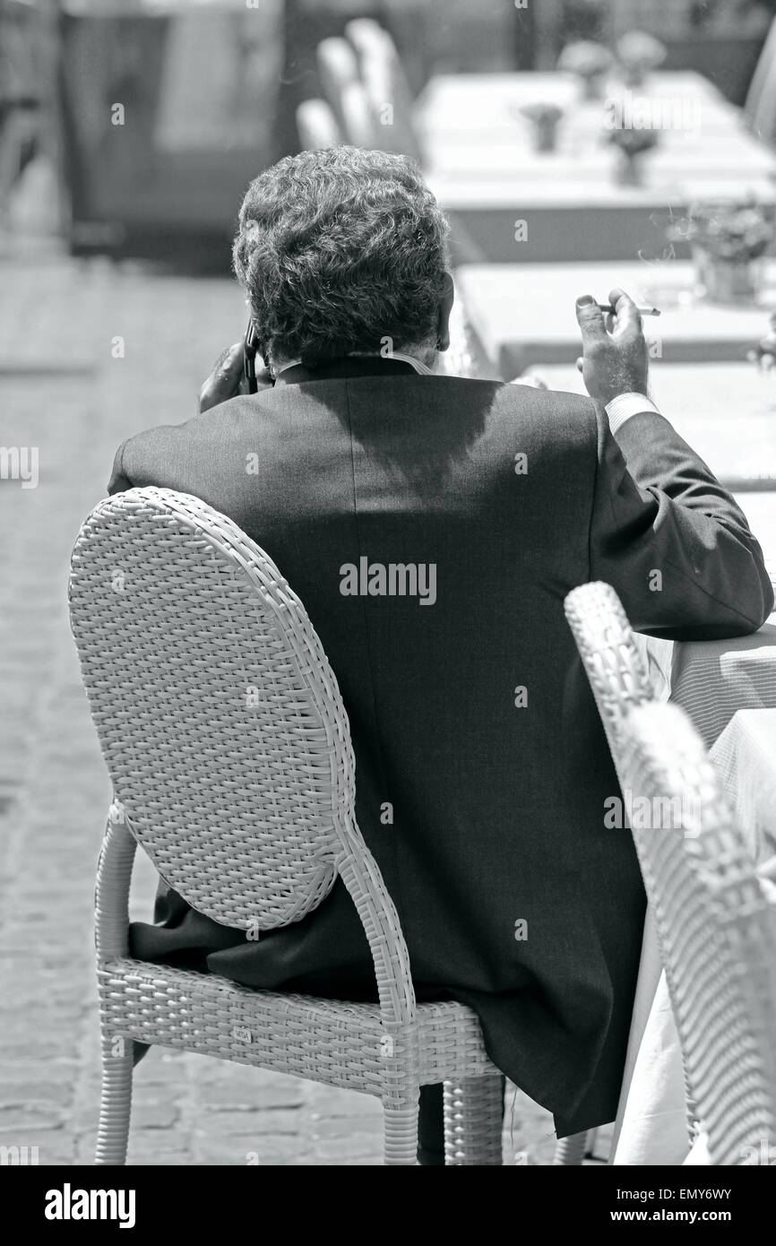 Man sitting at a table smoking Stock Photo - Alamy
