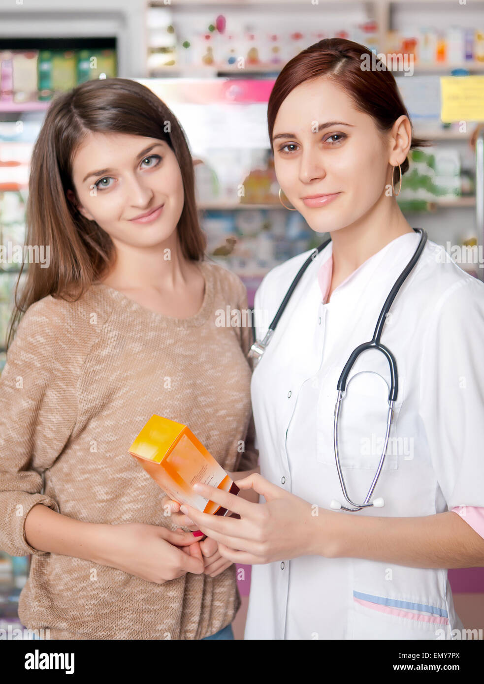 Woman doctor and client inside pharmacy consulting the client ...