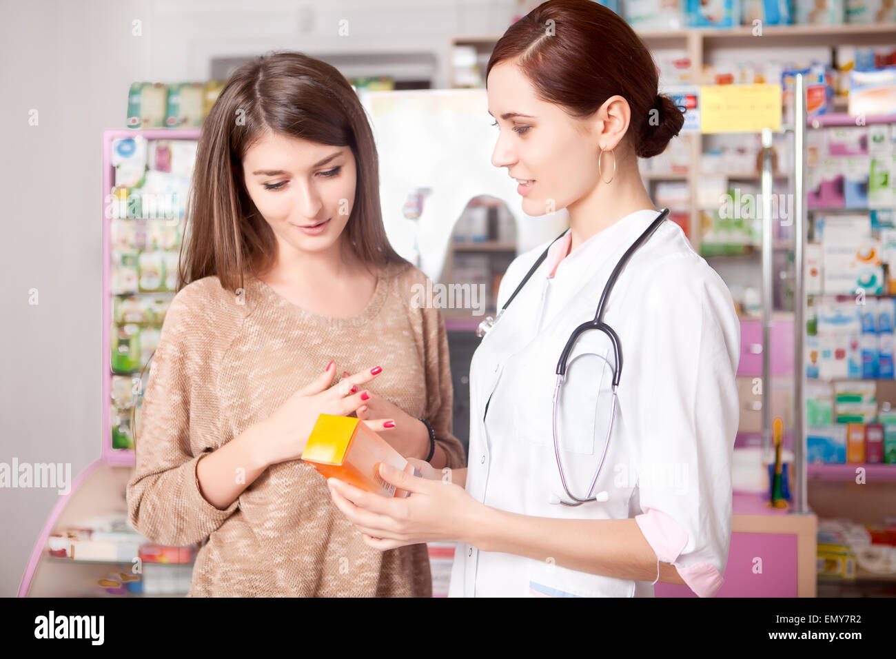 Woman doctor and client inside pharmacy consulting the client ...