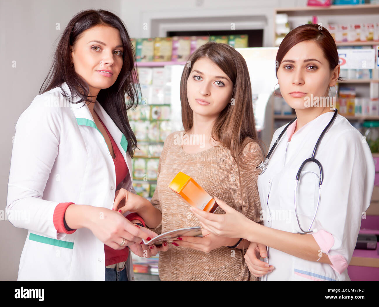 Two doctors and one client inside pharmacy. The medics are consulting ...