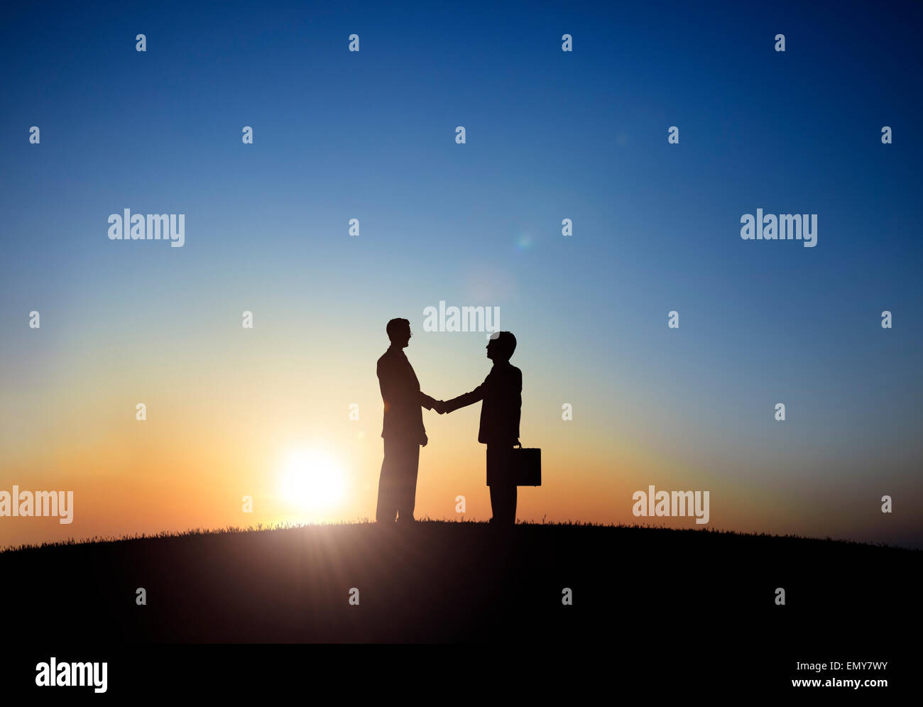 Two Businessmen Shaking Hand in Back Lit Stock Photo - Alamy
