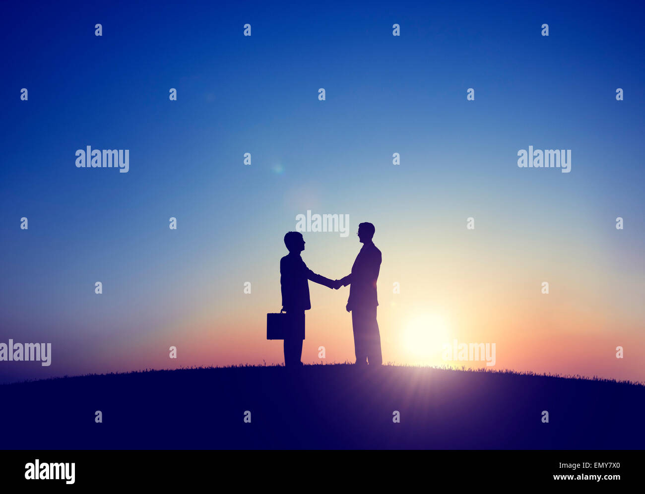 Two Businessmen Shaking Hand in Back Lit Stock Photo - Alamy