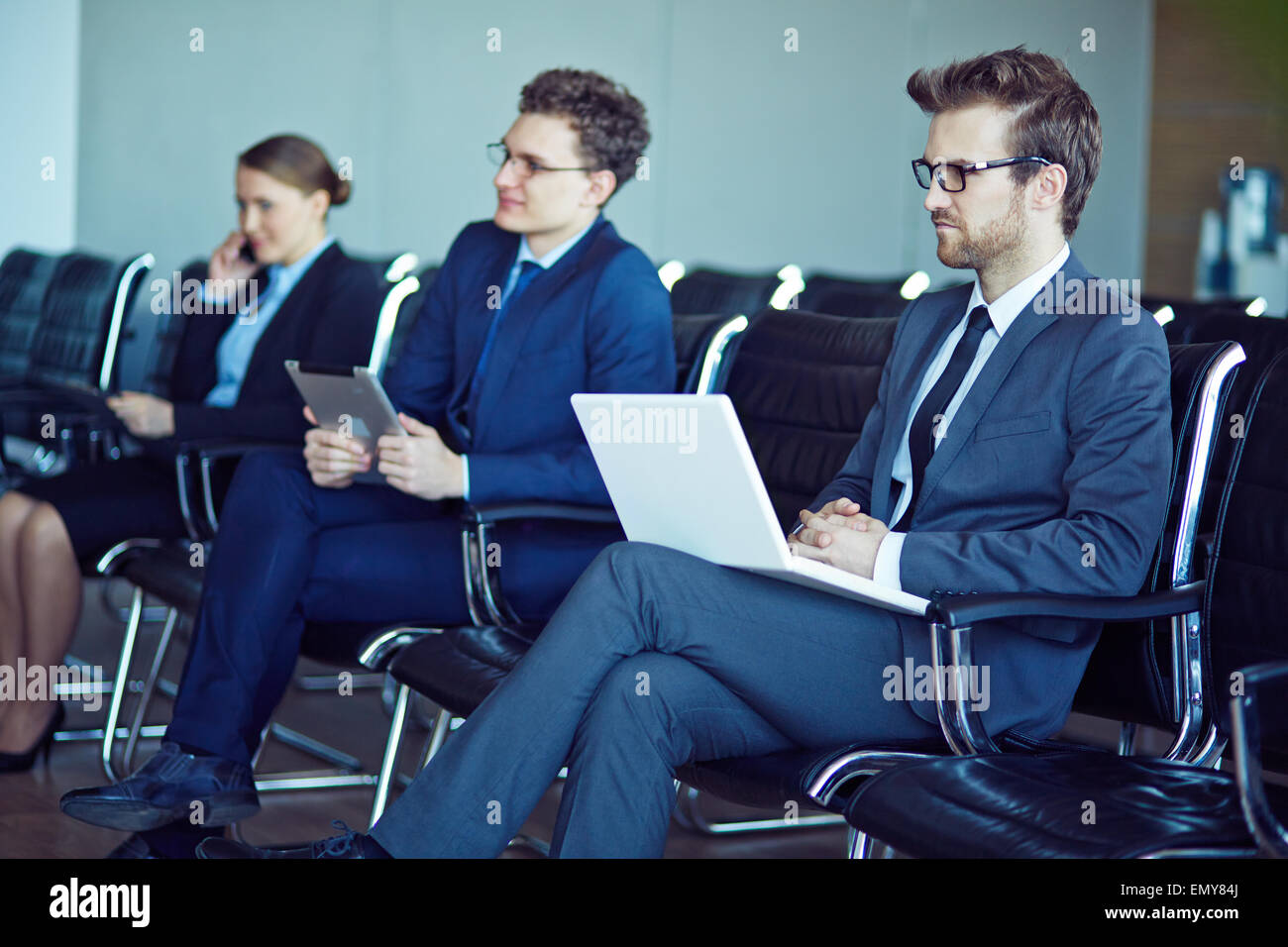 Row of elegant business people sitting at conference Stock Photo - Alamy