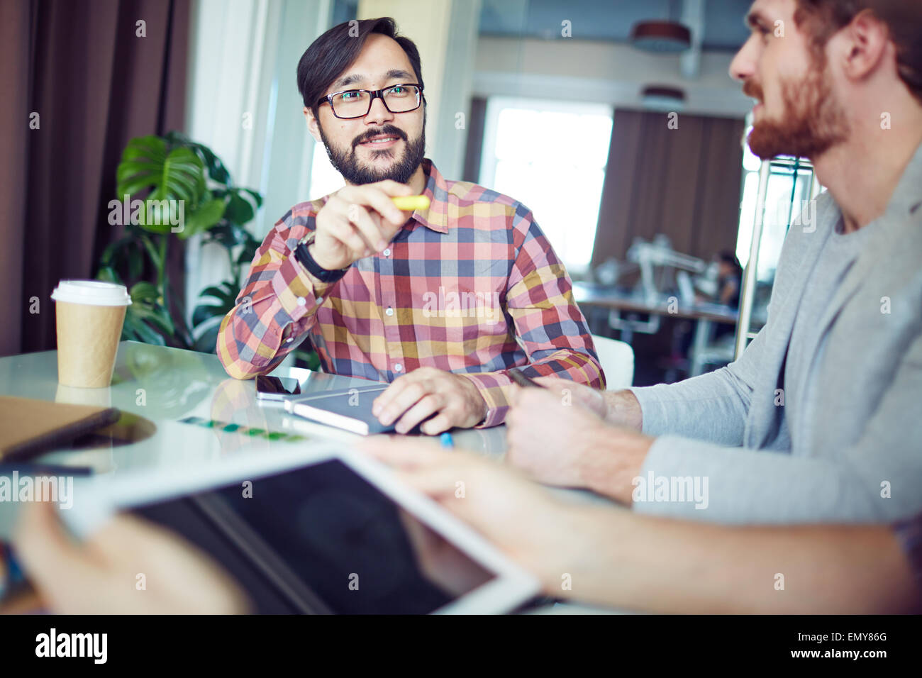 Asian businessman answering questions of his colleagues Stock Photo - Alamy